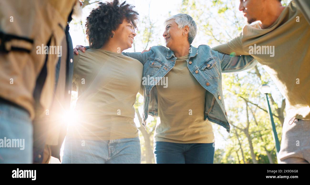 Hug, volunteer and group in park, sunshine and teamwork with ...