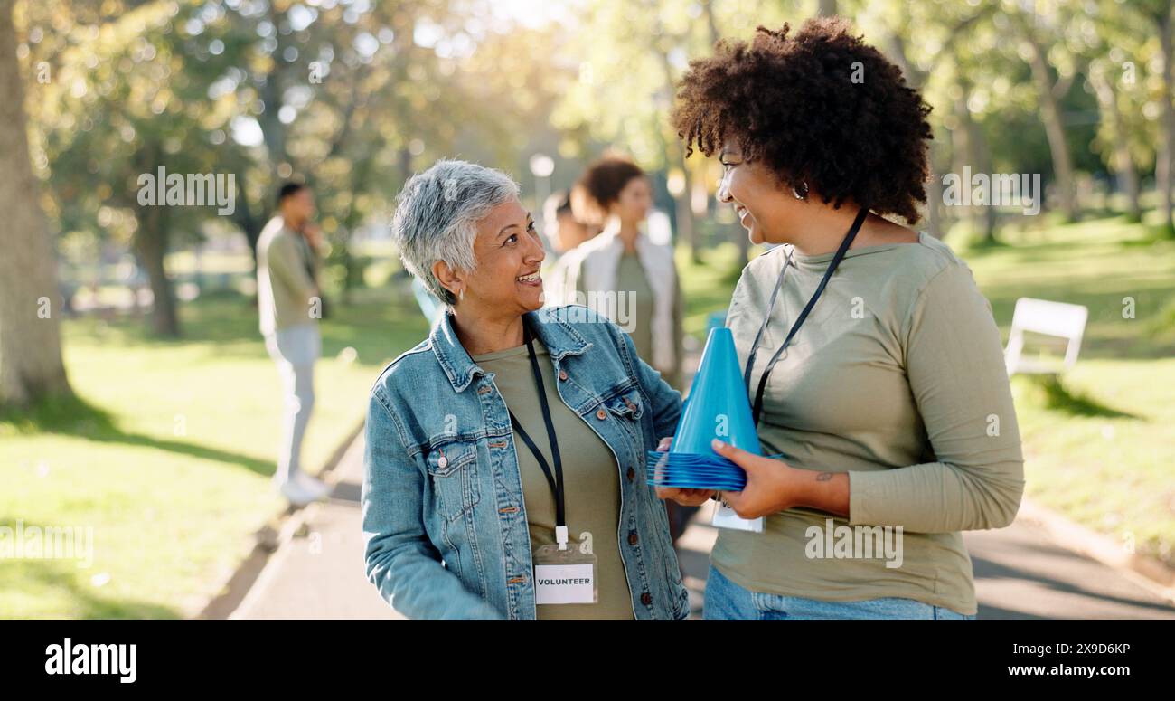 Happy, woman and volunteer talking in outdoors of traffic cones for ...