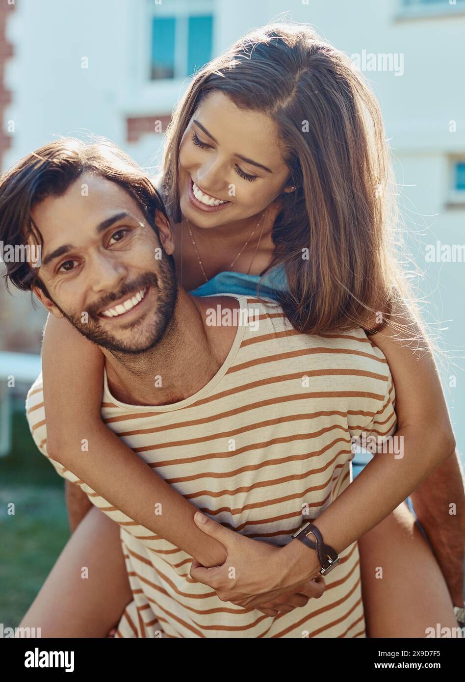 Couple, piggy back and smile in portrait with sunshine, bonding and ...