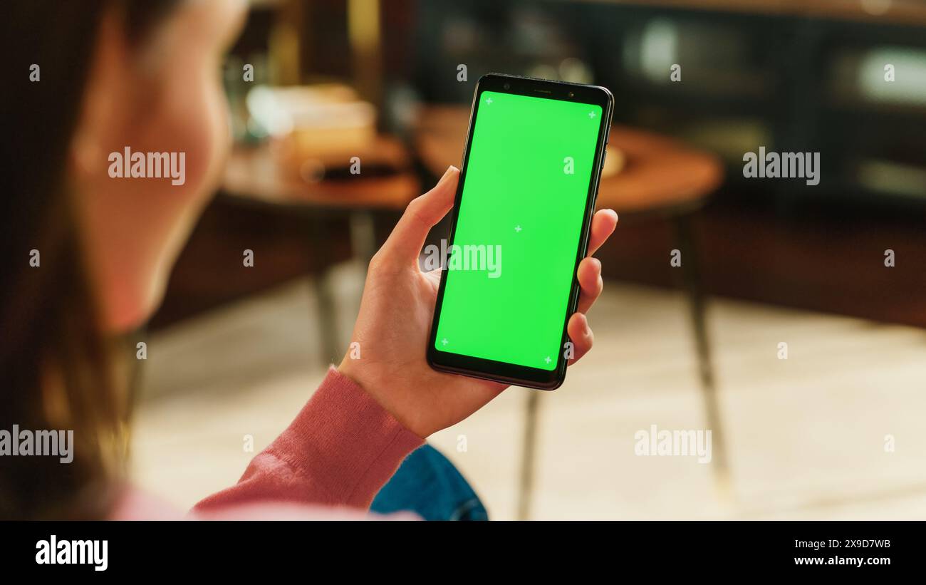 Feminine Hand Holding a Smartphone with Green Screen Mock Up Display ...