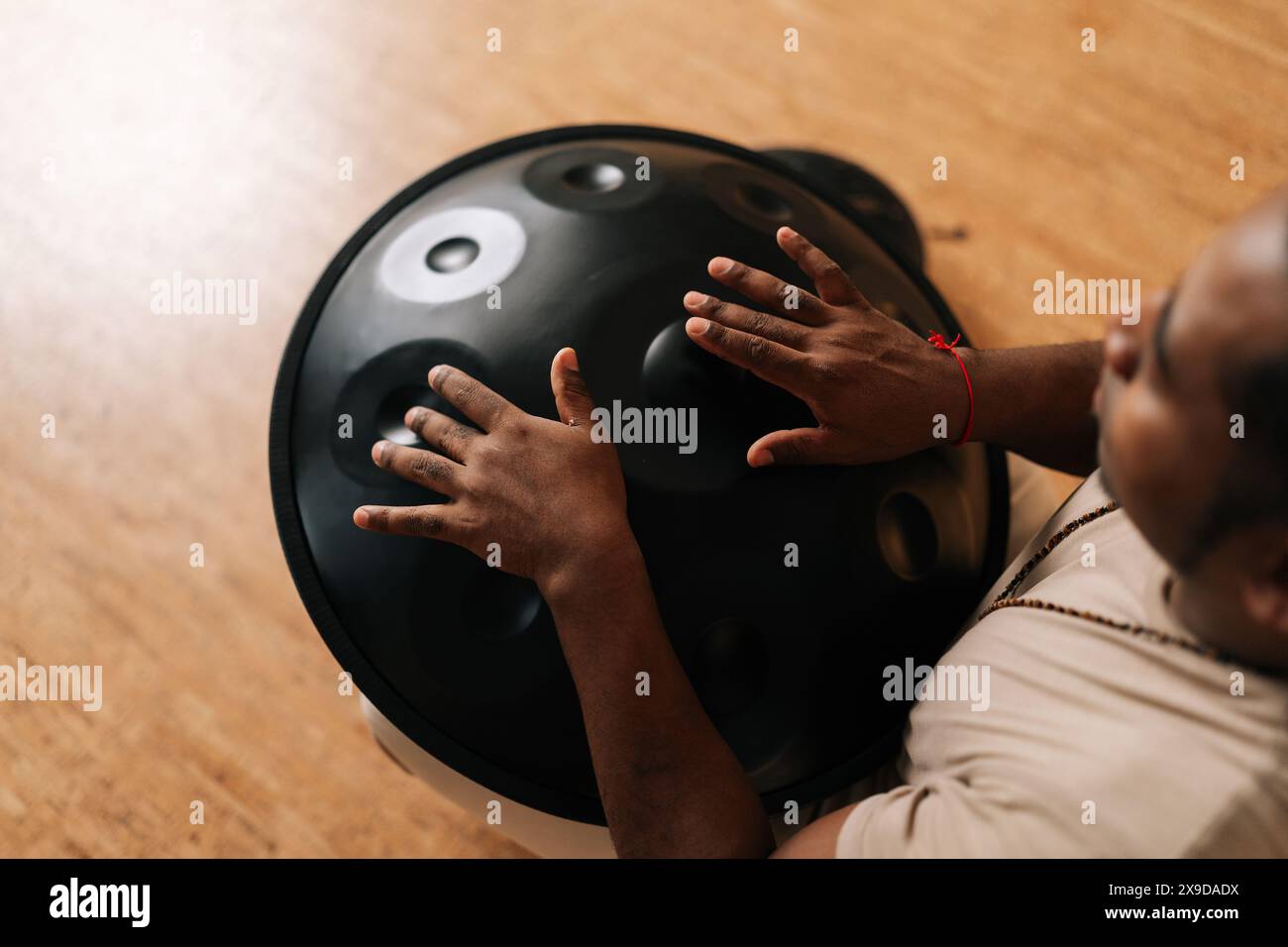 Top view of relaxed African drummer playing traditional ethnic music ...