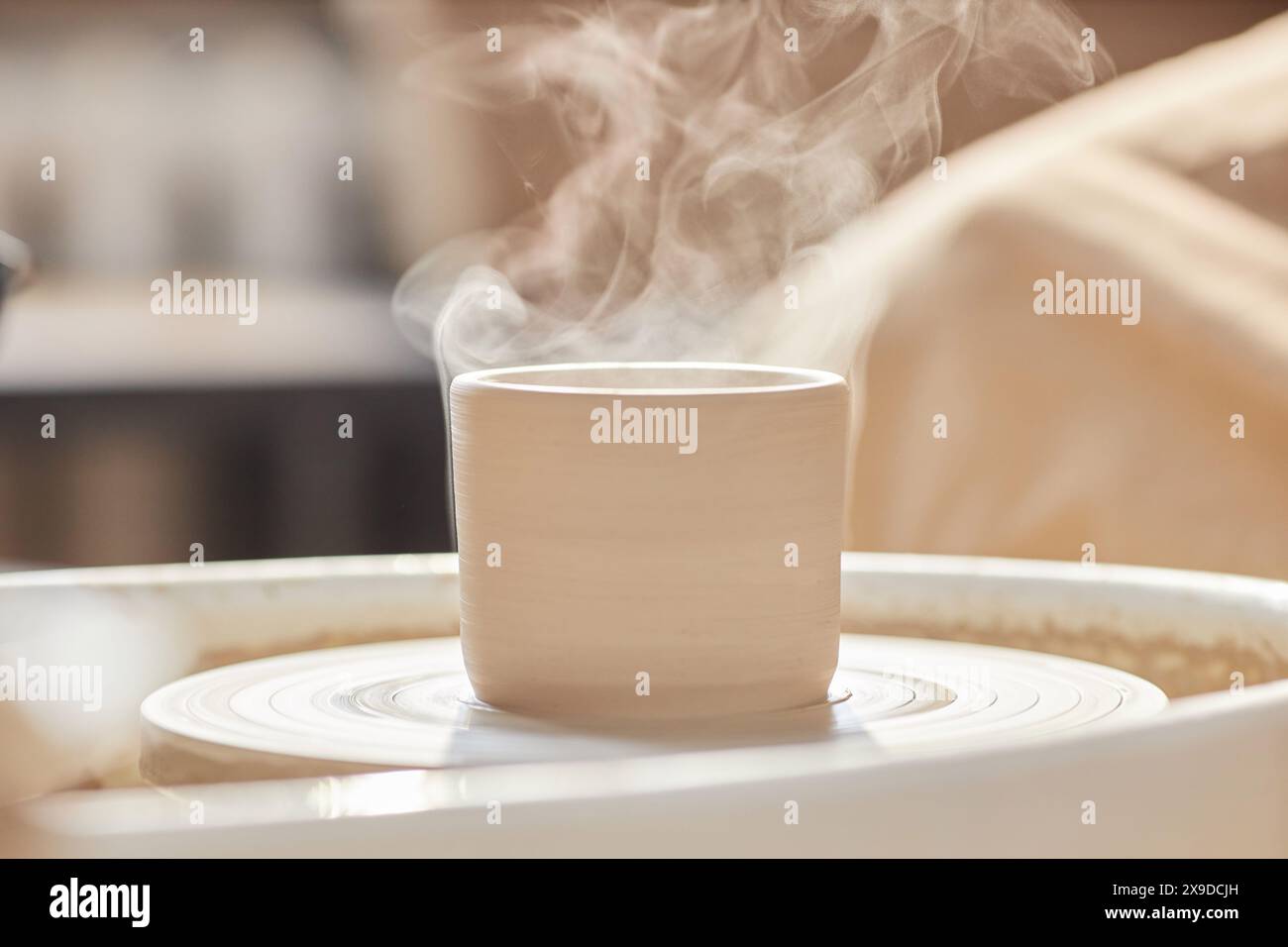Minimal background image of raw clay piece smoking on pottery wheel in ...