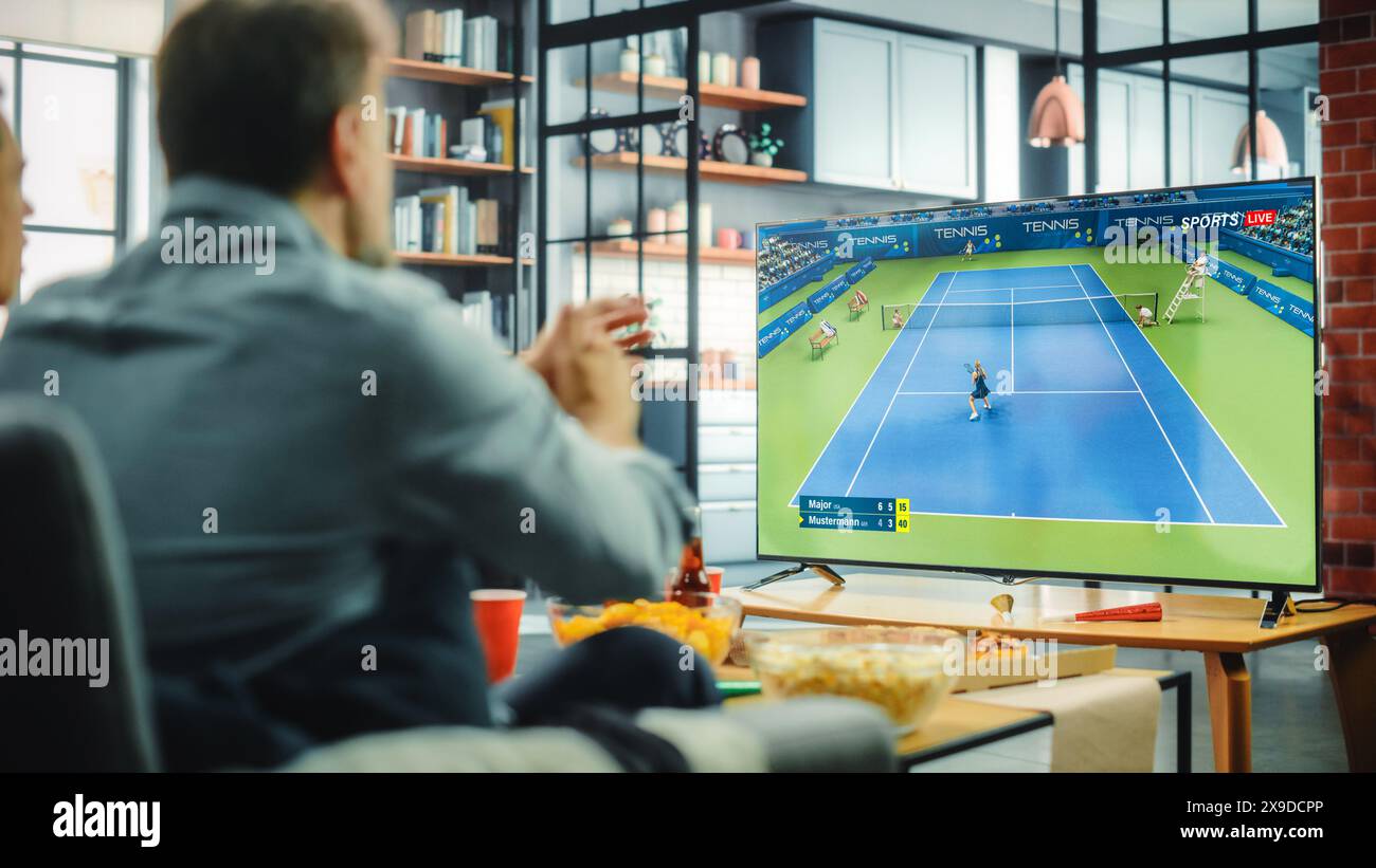 At Home Tennis Fans Sitting on a Couch Watch Game on TV. Cheer when ...