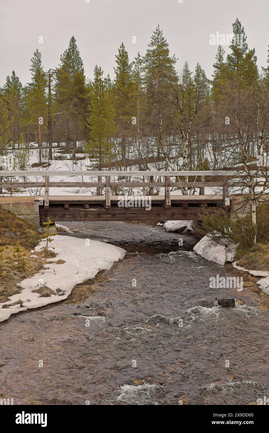 Old wooden Laanioja bridge over small Laanioja stream in cloudy spring ...