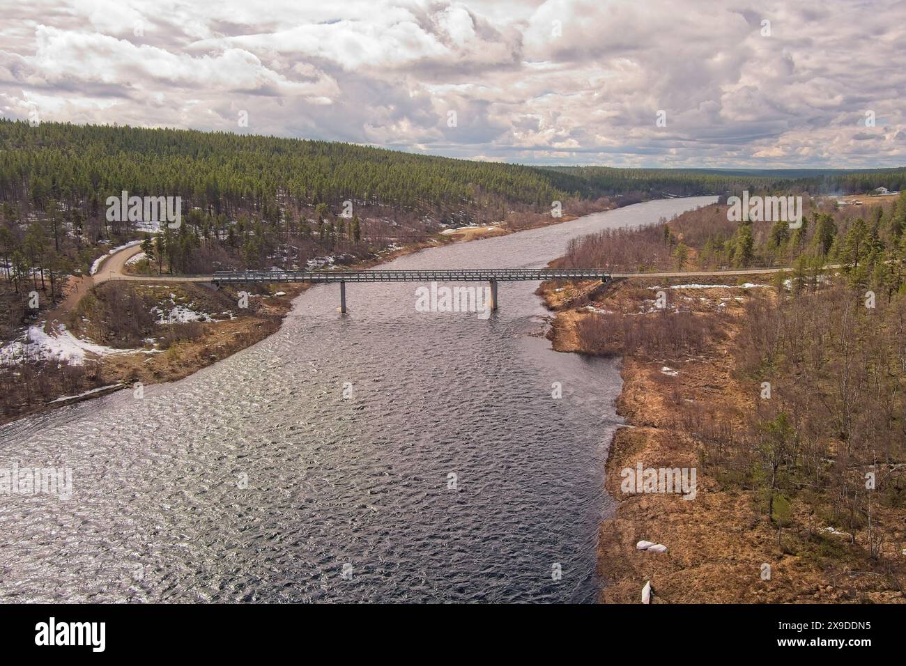 Aerial view of Kuttura bridge over Ivalojoki river in cloudy spring ...