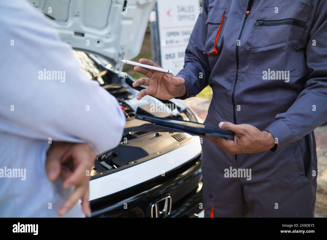 Technicians from service center inspect and assist customers cars that ...
