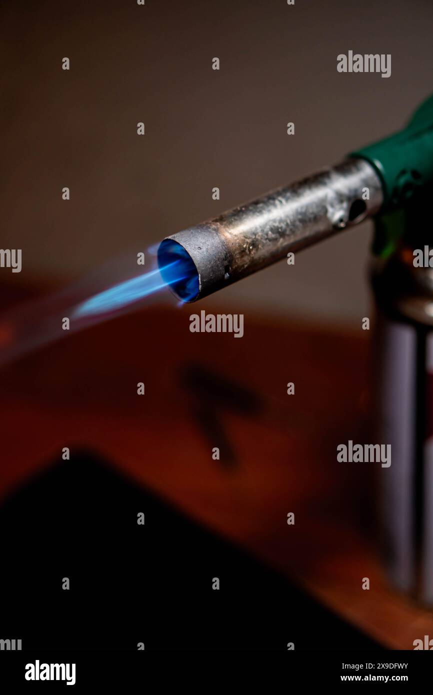 Close-up of a gas blow torch with a blue flame Stock Photo - Alamy