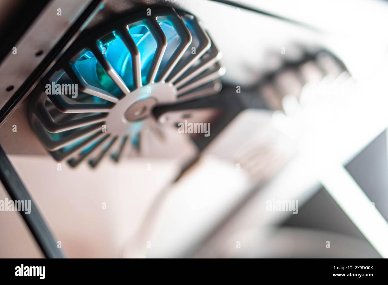 Close-up of a cooling fan with blue LED lights inside a computer case ...