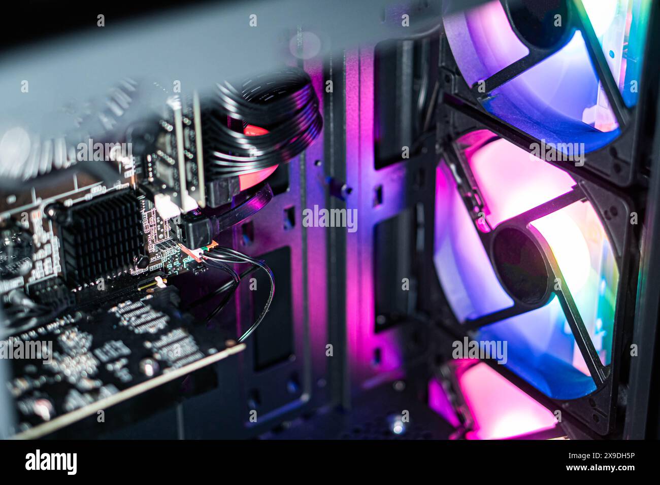 Close-up of a computer case interior with RGB lighting and cooling fans ...