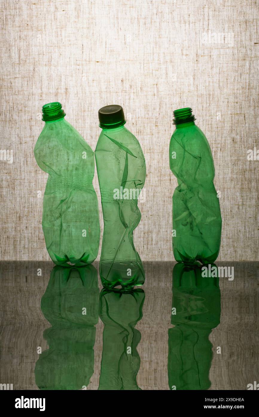 Three crumpled plastic bottles on a reflective surface Stock Photo - Alamy
