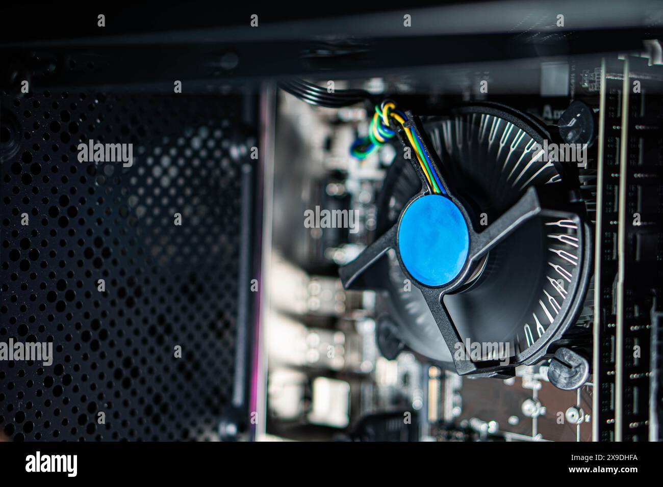 Close-up view of a computer CPU cooler with a blue fan inside a desktop ...