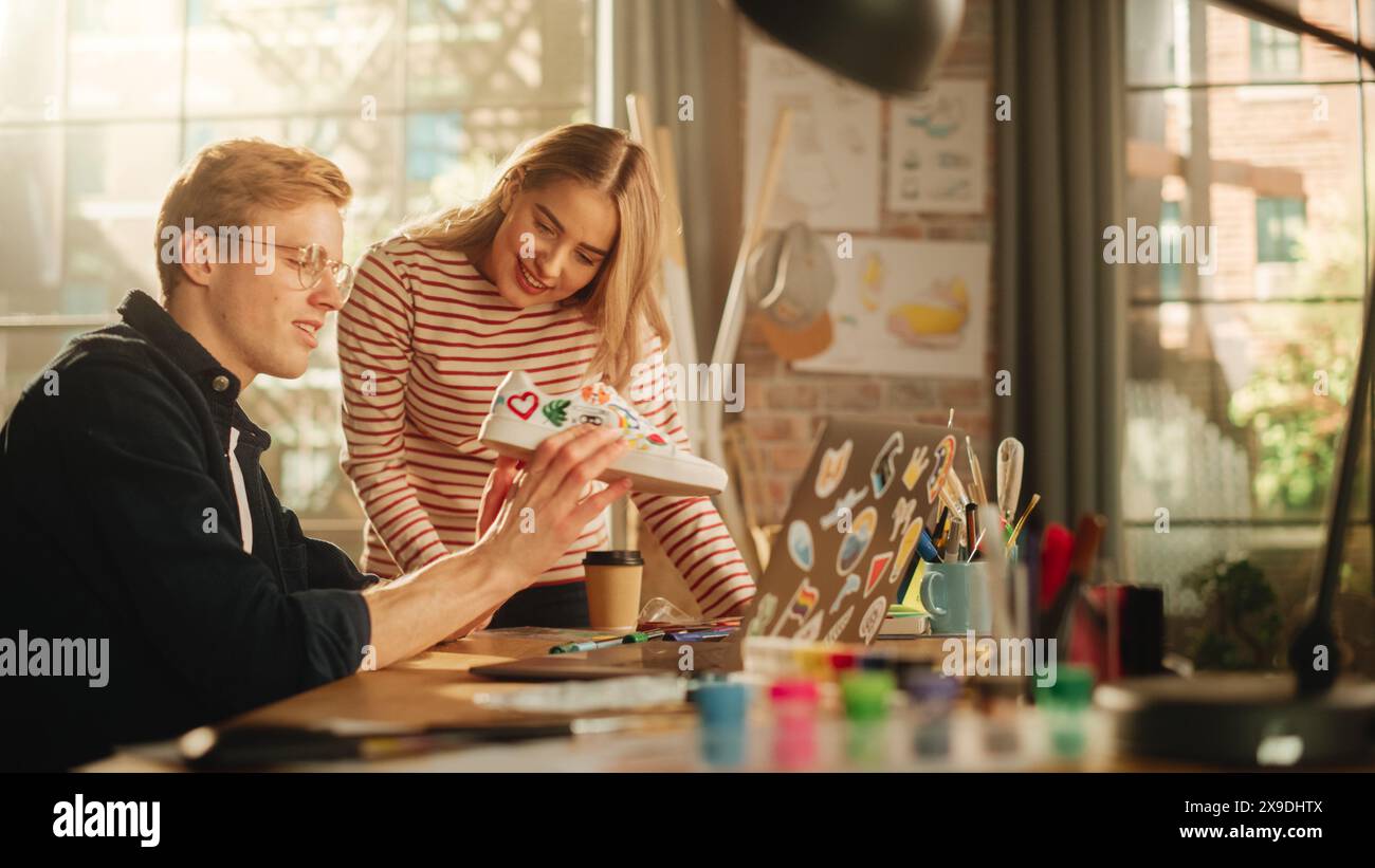 Young and Positive Female Artist Looks at Screen and Shares Ideas With her Male Colleague Who ...