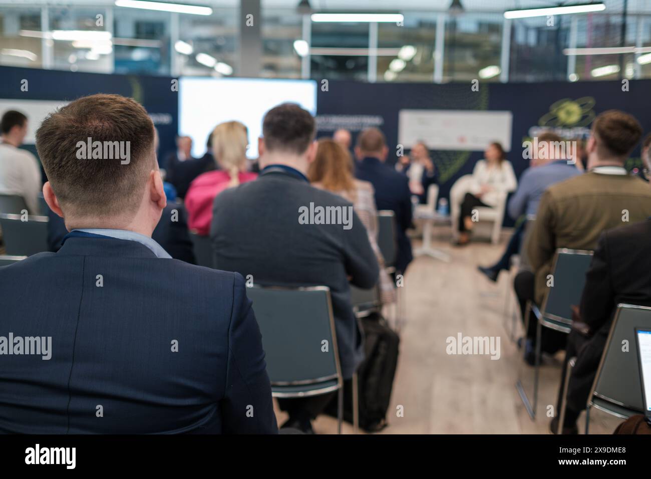 Business professionals attending a conference, listening to speakers in ...