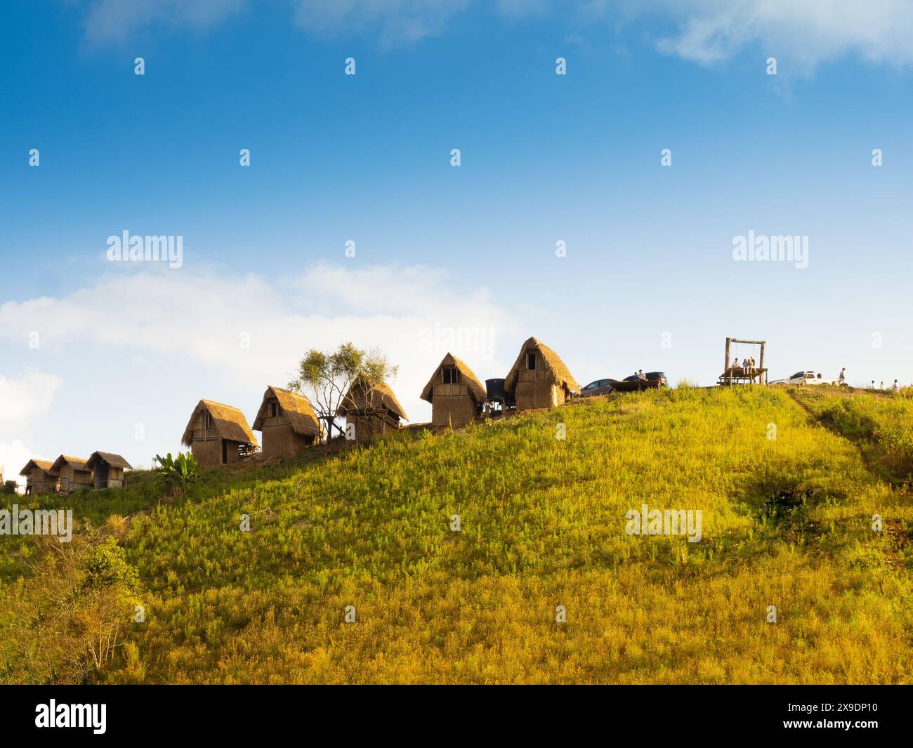 Small wooden huts on mountain grass hills under blue sky and clouds ...