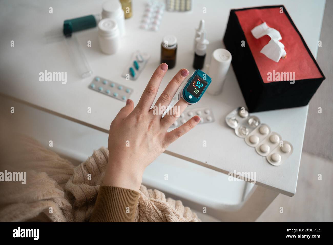 adult woman's hand with pulse oximeter attached to the fingertip ...
