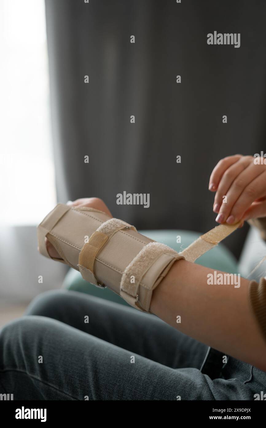 woman attaches splint for her arm with velcro. Tendon inflammation ...
