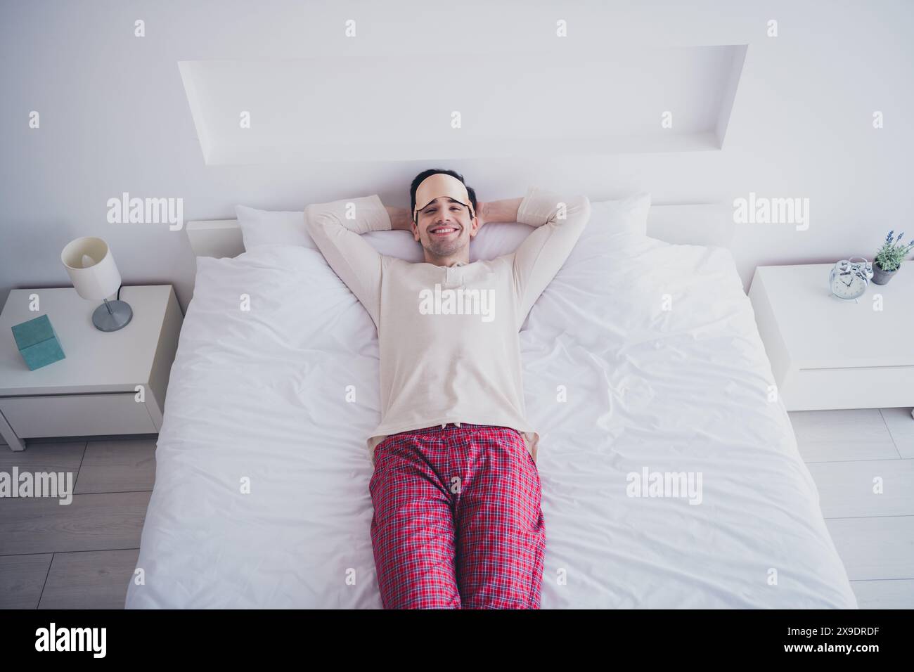 Photo of happy dreamy man enjoying lying in soft comfortable cosy bedrooom bed white interior ...