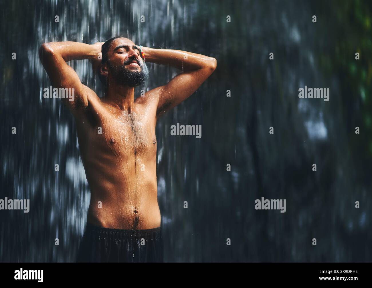 Man, waterfall and happy in nature on travelling trip, eyes closed and ...