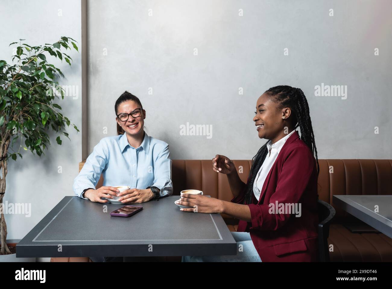 Two young businesswoman team workers, office workers colleagues and ...