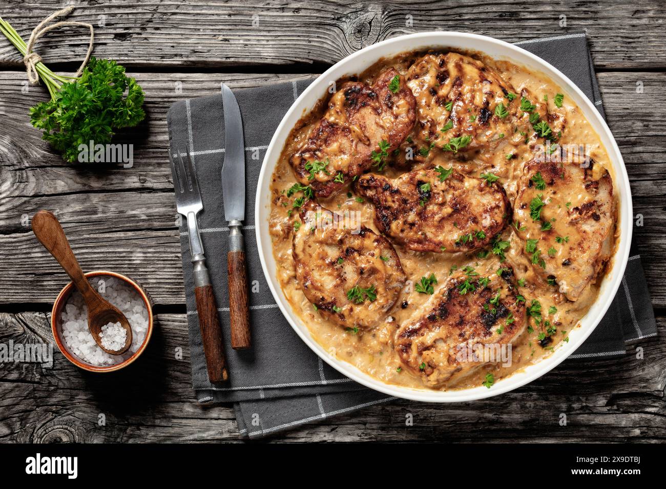 creamy smothered pork chops cooked in onion gravy in baking dish on ...