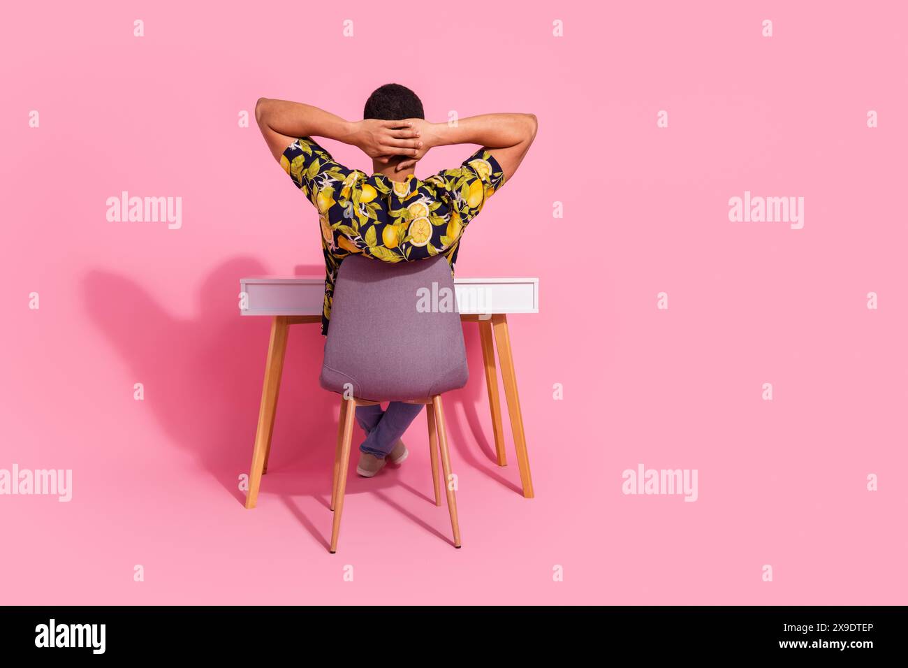 Back view photo of guy worker sit hands overhead rest isolated pastel ...
