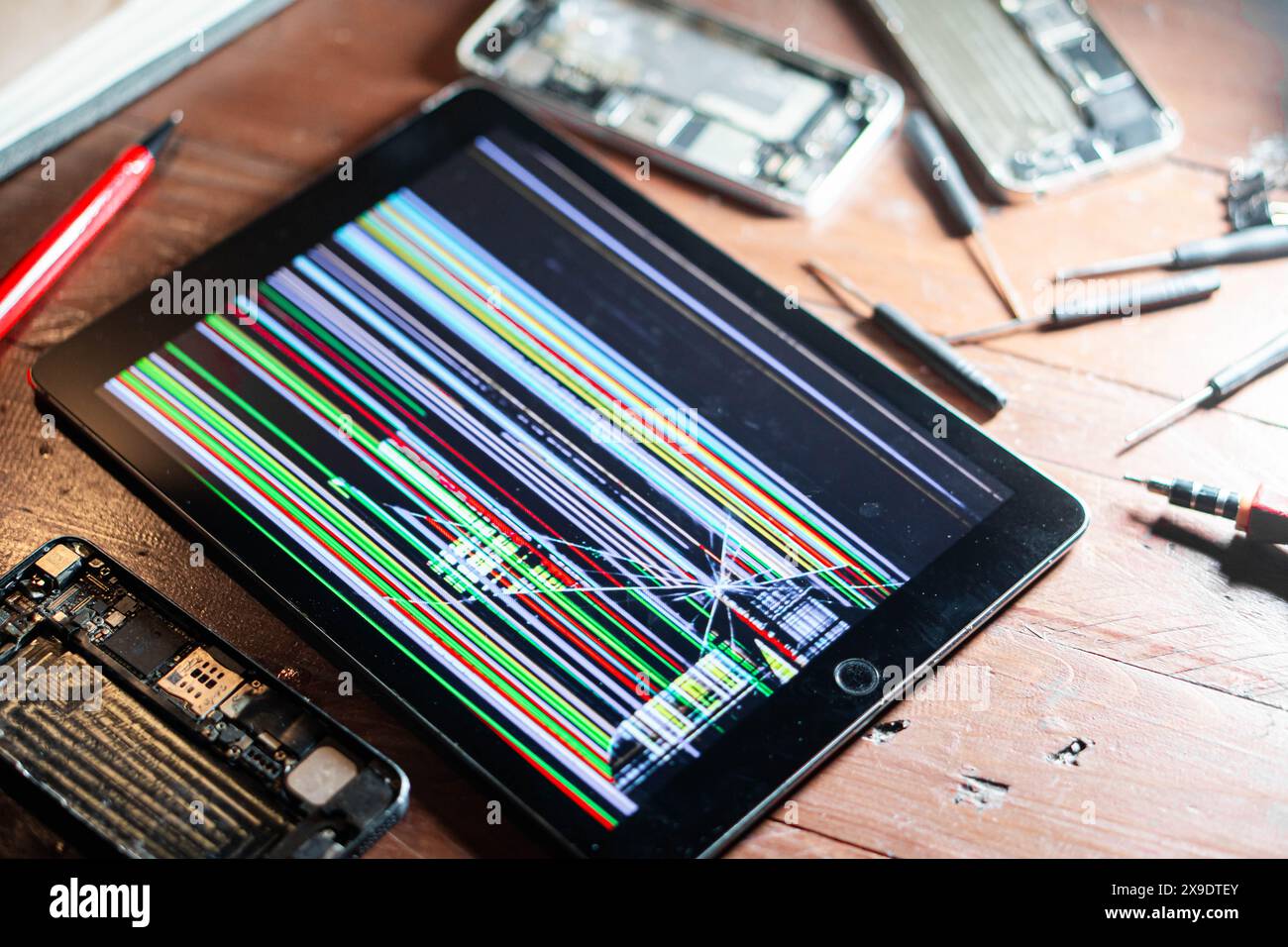A damaged tablet with a distorted screen displaying colorful vertical ...