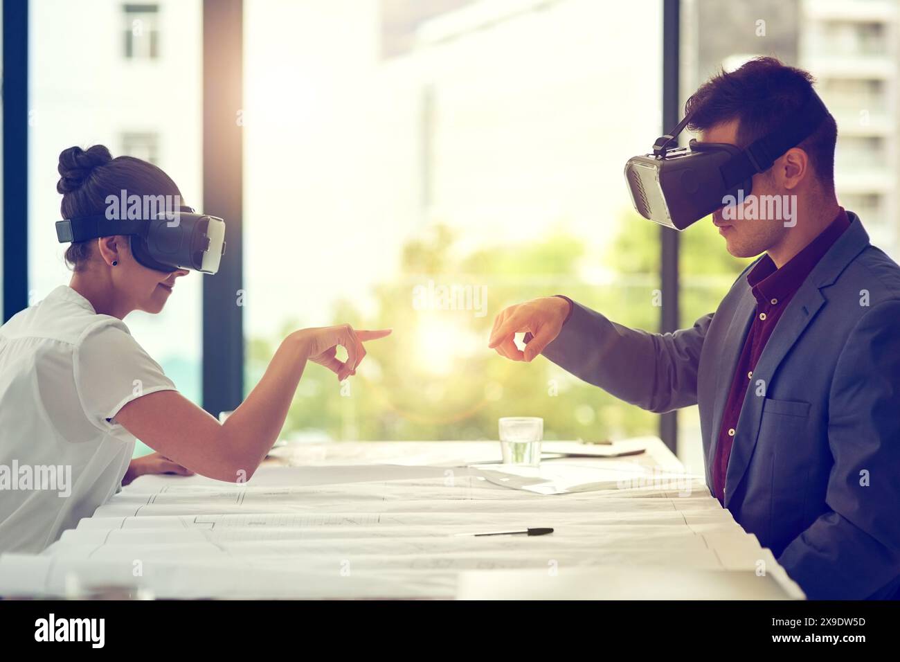 Woman, man and virtual reality for architecture, blueprint and touch in ...