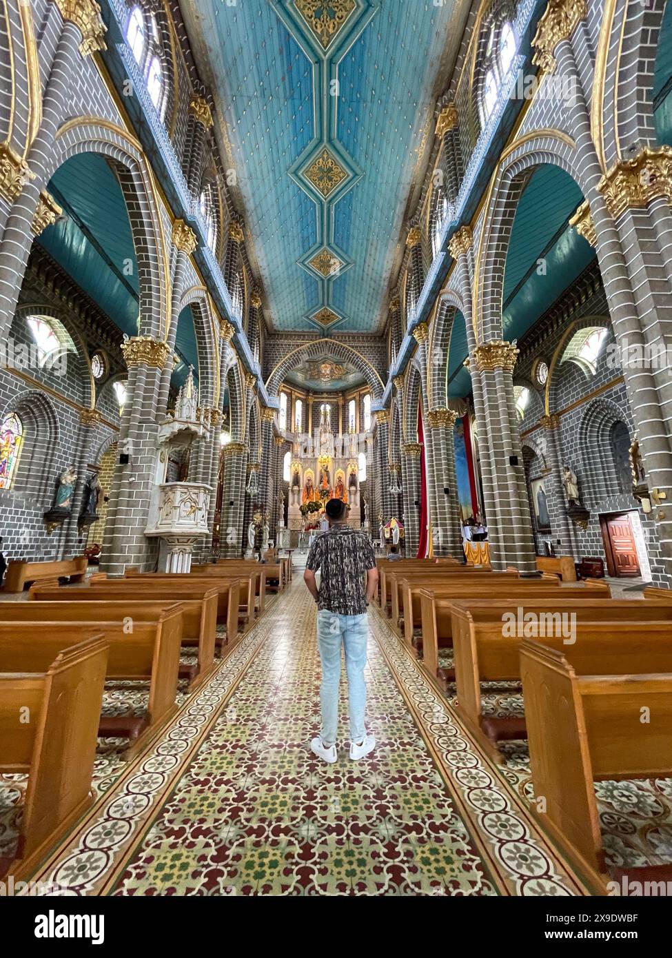 A visitor stands inside a beautifully ornate church, admiring the ...