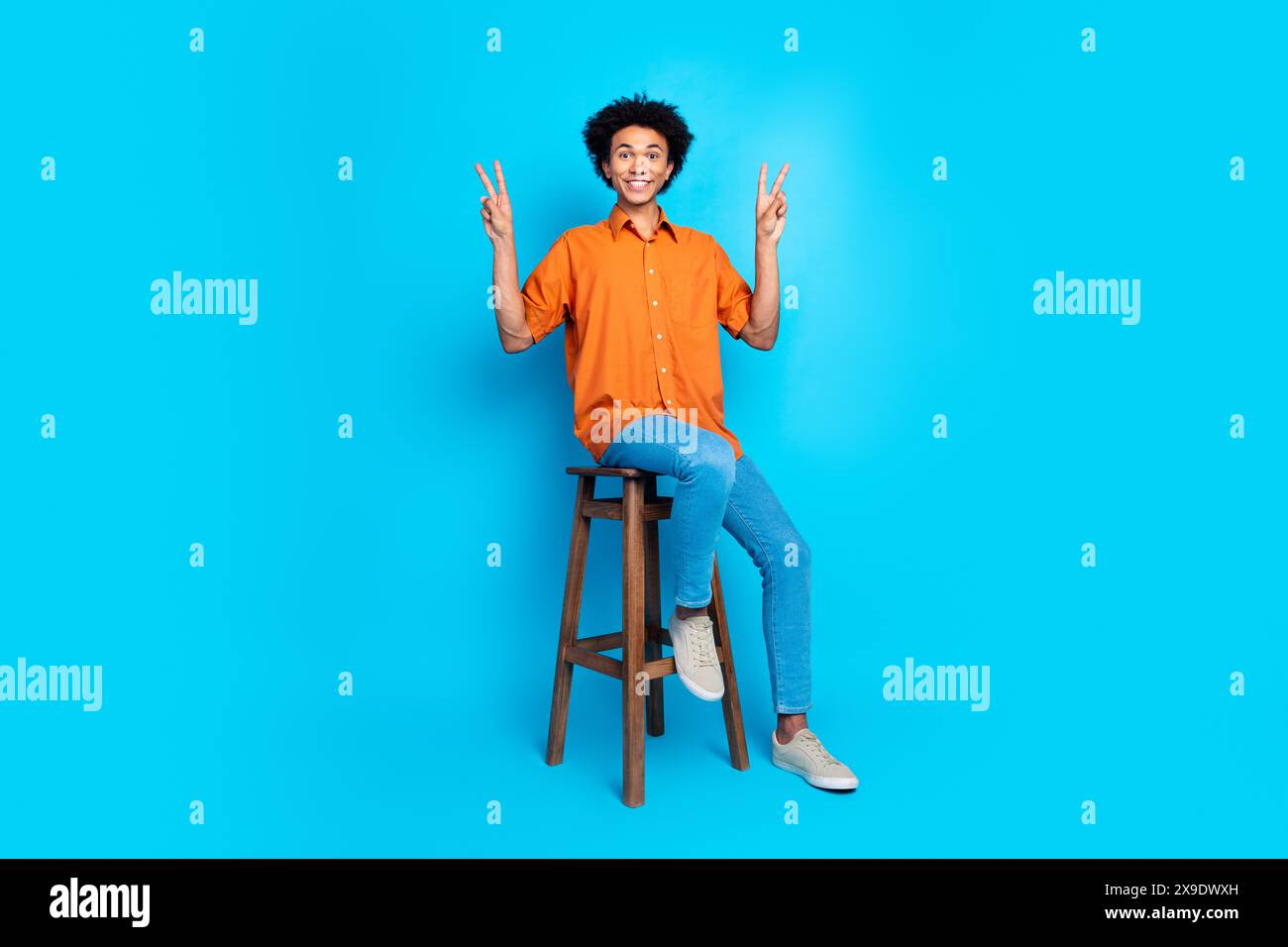 Full length photo of attractive funny guy wear orange shirt sitting ...