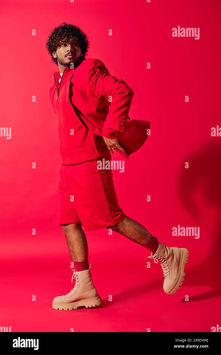 Handsome Indian man in red hoodie striking a pose against a vibrant ...