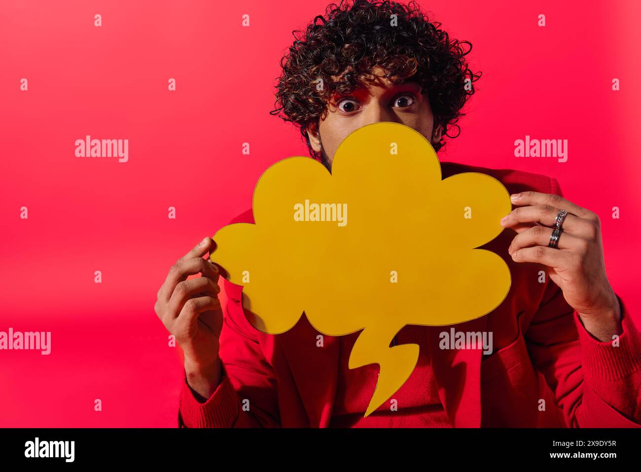 A man holding a speech bubble over his face, showcasing mystery and ...