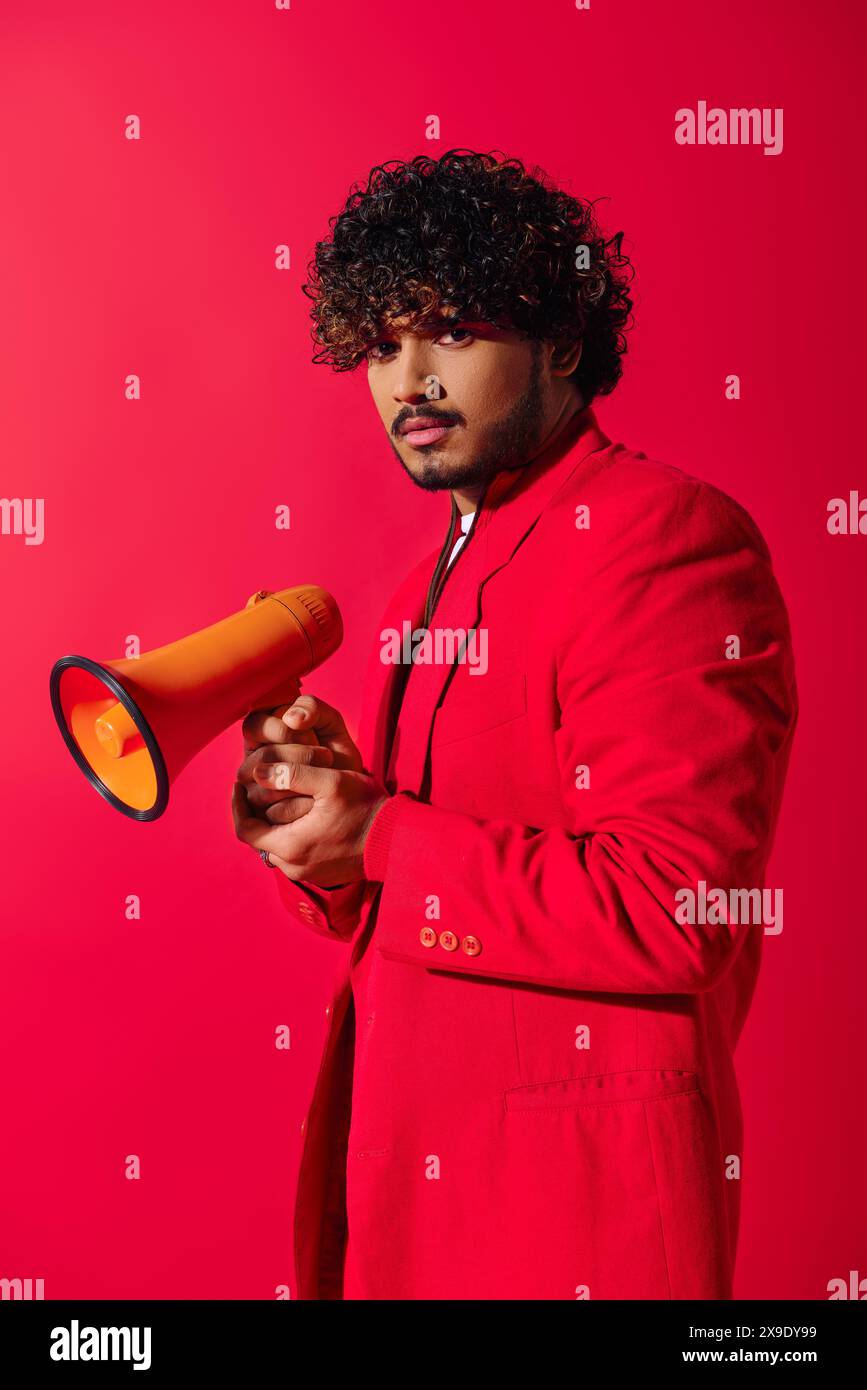 Young Indian man in red suit holding red and yellow megaphone Stock ...