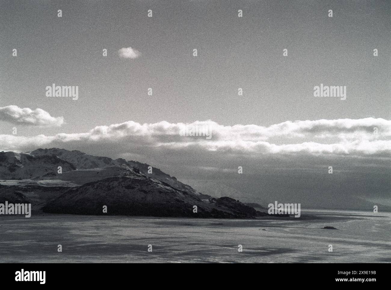 A small mountain in the distance surrounded by sand and clouds Stock ...