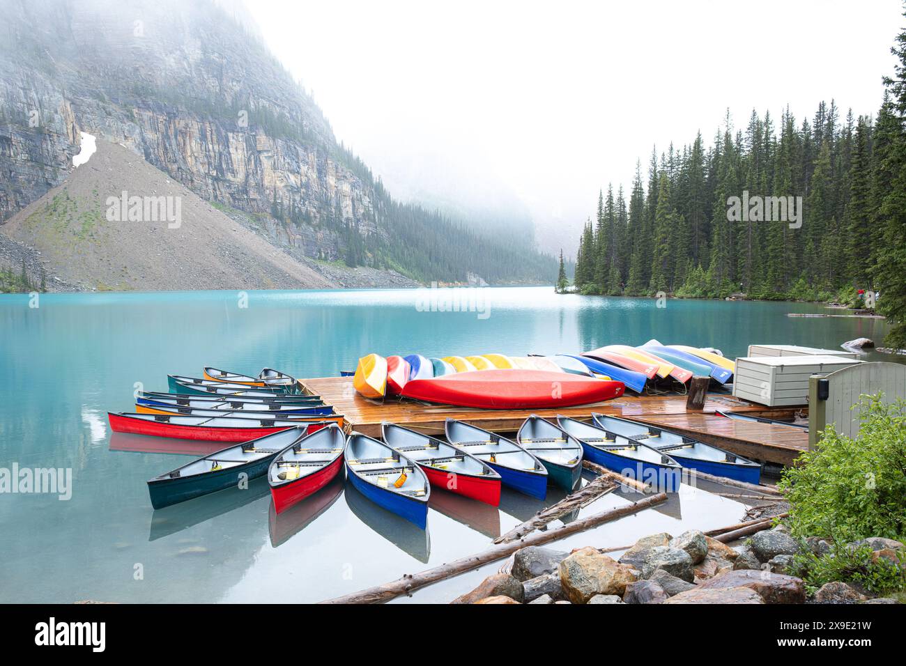 Colorful canoes surround a dock at Moraine Lake in Canada Stock Photo ...
