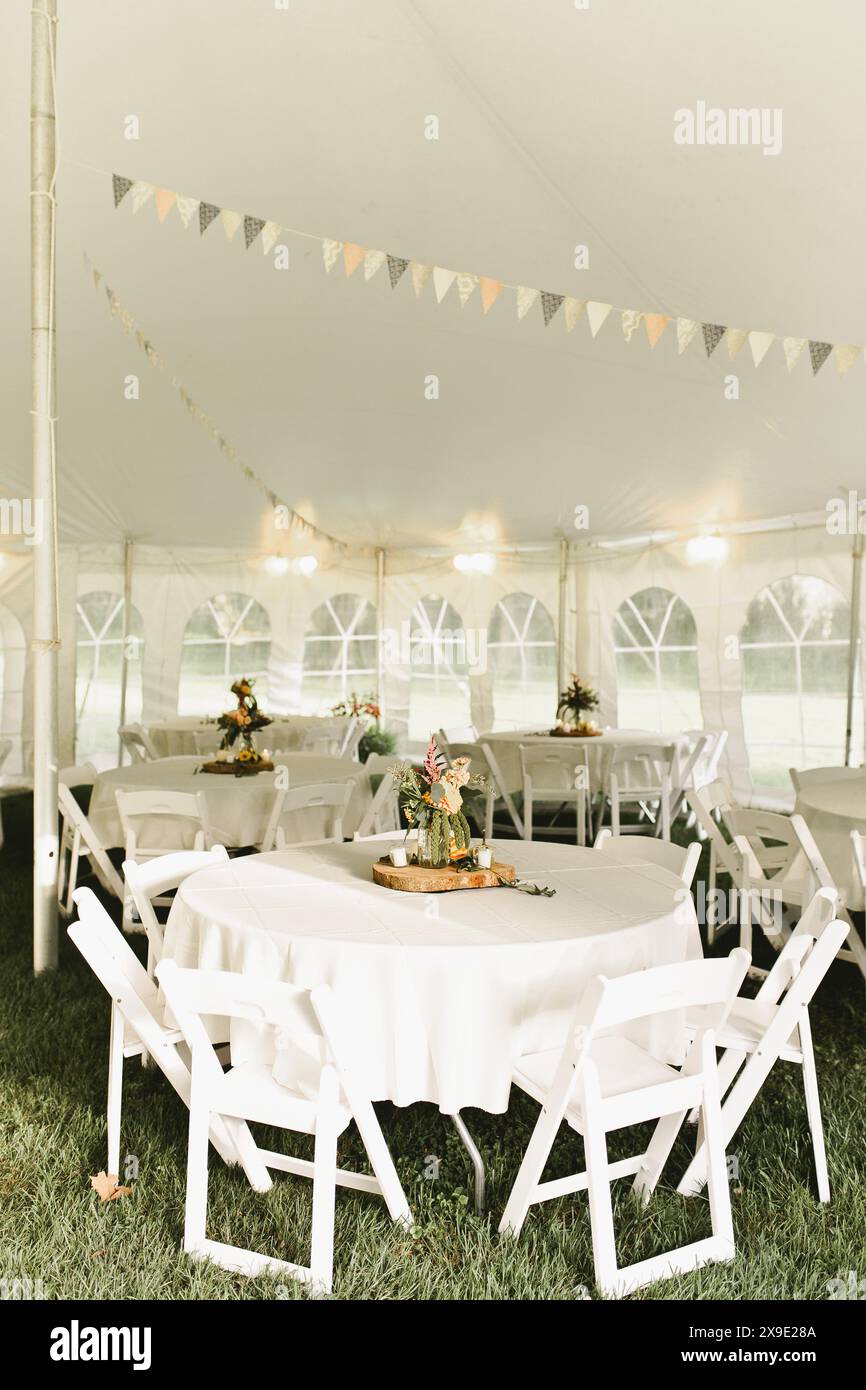 White tables and chairs in tent with bunting hanging above Stock Photo ...