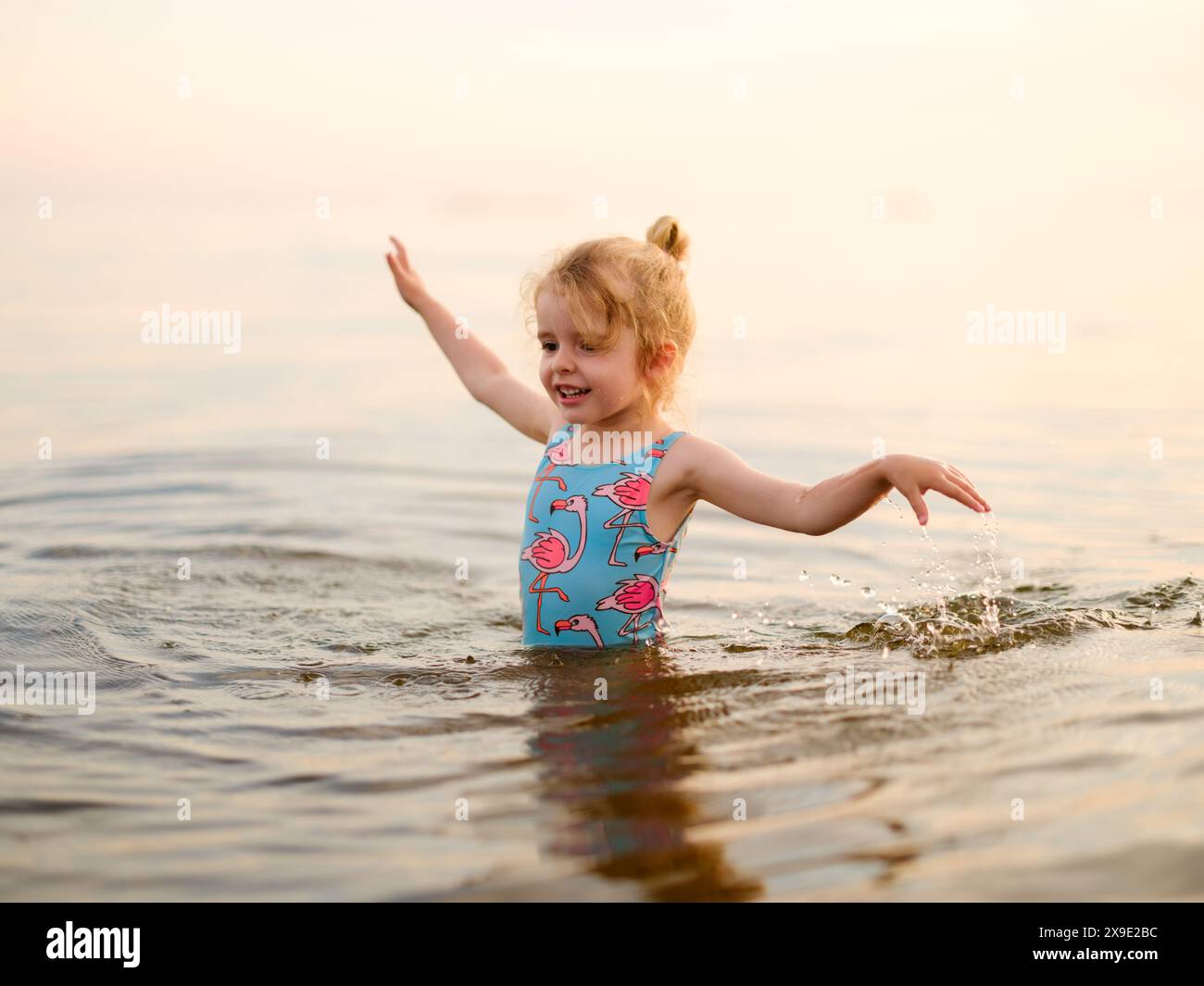 Funny little girl child splashing in lake water in summer Stock Photo ...