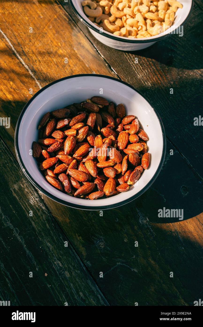 Bowls of almonds and cashews on a rustic outdoor table Stock Photo - Alamy