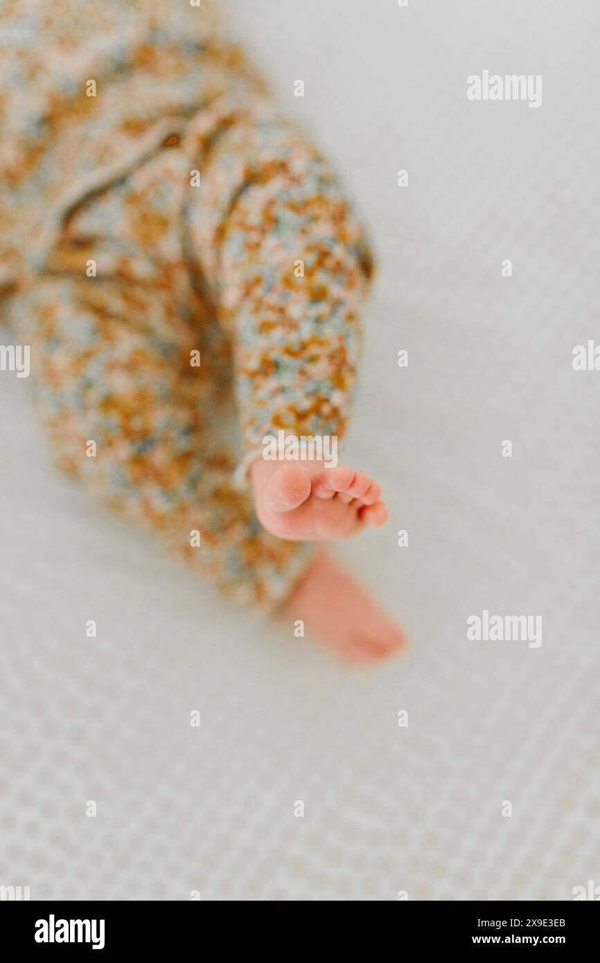 Newborn baby girl lays in crib with toes in air Stock Photo - Alamy