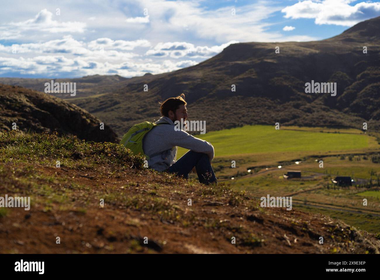 Man sitting on a mountain in Iceland. River valley view point 1 Stock ...