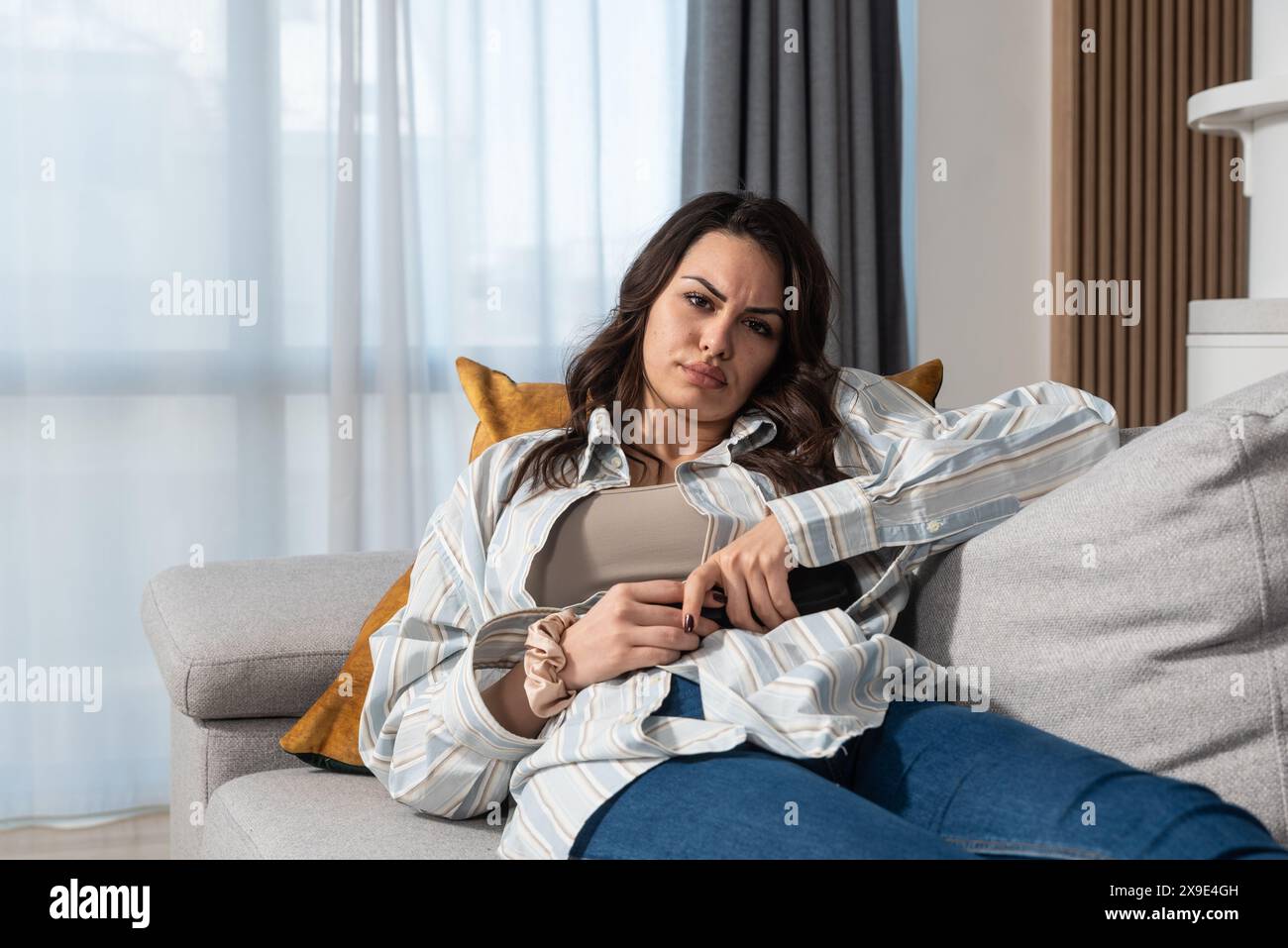 Laziness concept. Young lazy woman lying on the couch watching ...