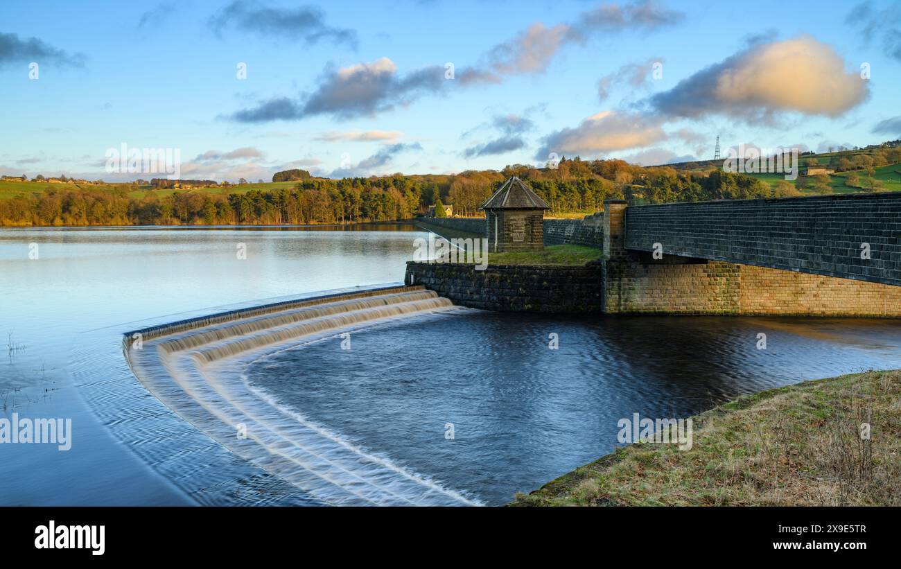 Water tumbling down steps from calm scenic man-made lake, under stone ...