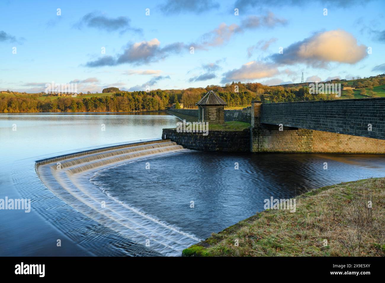 Water tumbling down steps from calm scenic man-made lake, under stone ...