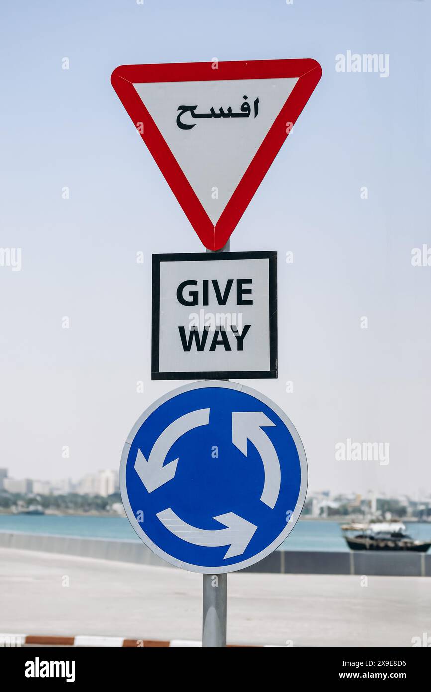 Roundabout and give way traffic sign in Doha, Qatar Stock Photo - Alamy