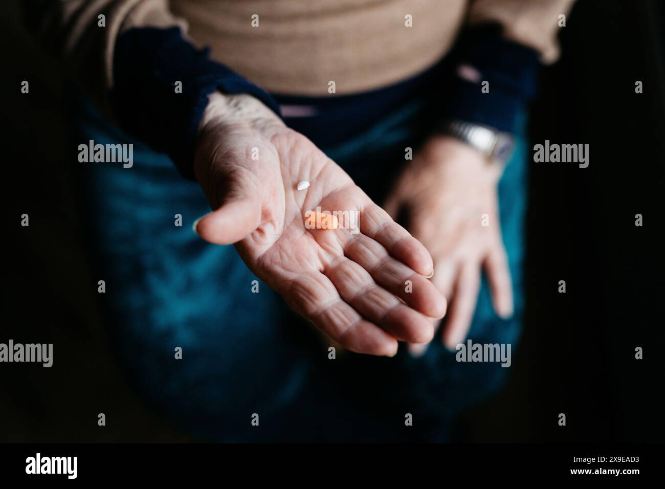 Close up of elderly woman's hand showing a few pills, emphasizing the ...