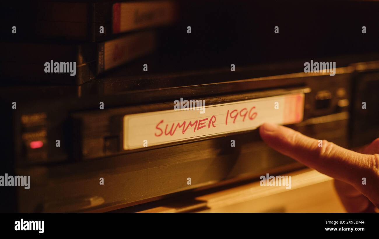 Close Up of a Person Inserting a VHS Cassette in a Player with ...