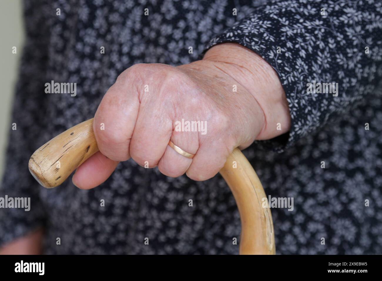 Walking disabilities. Close up of senior disabled woman leaning on her walking stick. Old woman ...