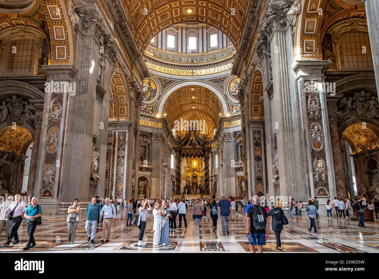 People walking through the central Nave inside St Peter's Basilica ...