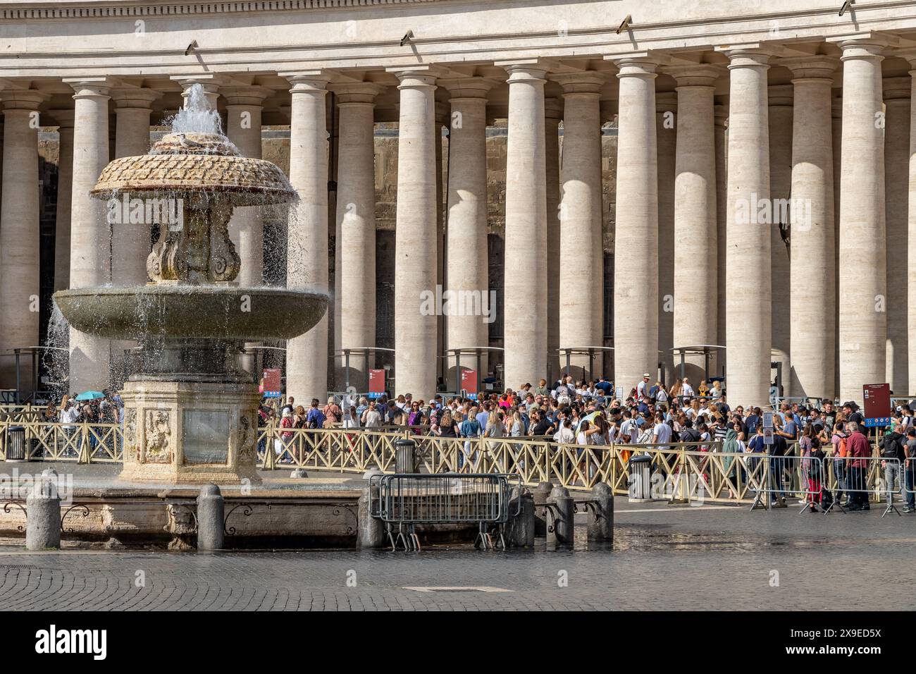 Crowds of people queuing by the Doric columns and Maderno fountain of ...