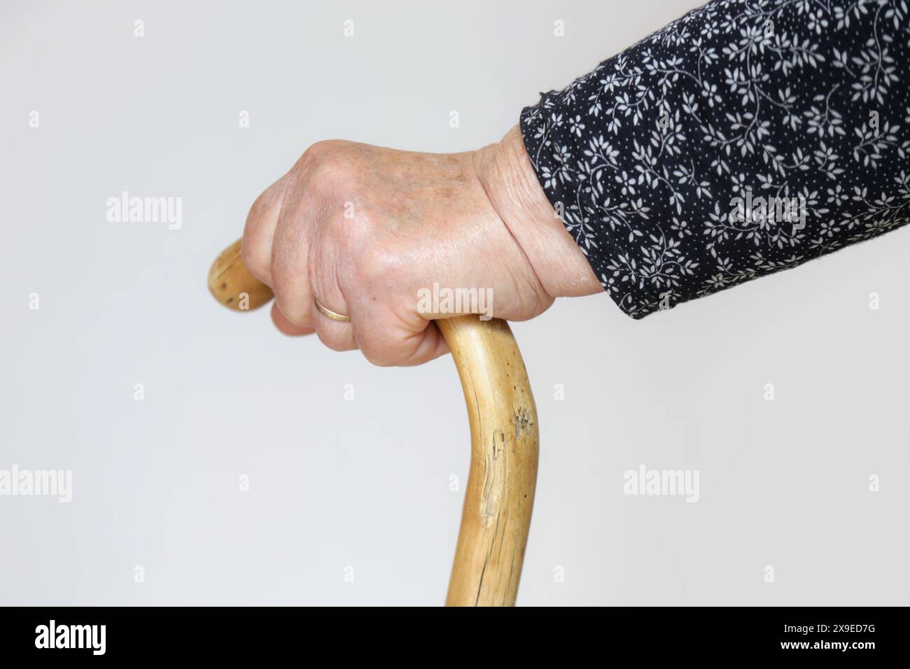 Walking disabilities. Close up of senior disabled woman leaning on her walking stick. Old woman ...