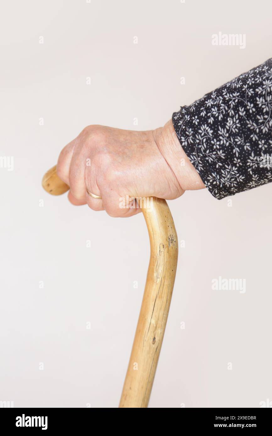 Walking disabilities. Close up of senior disabled woman leaning on her walking stick. Old woman ...